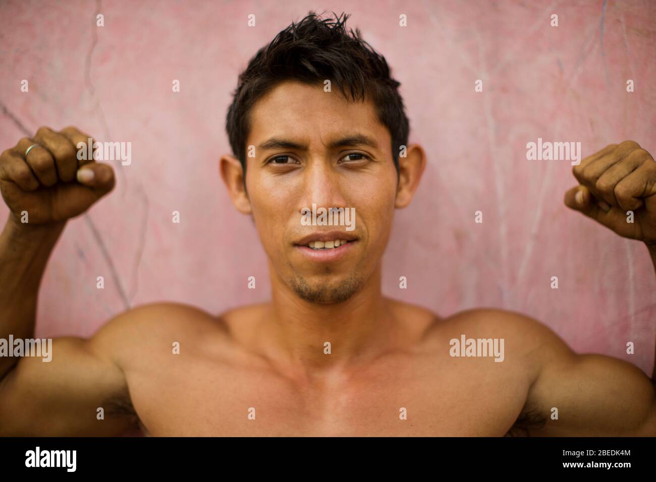 Portrait of a shirtless young man flexing his muscles Stock Photo - Alamy