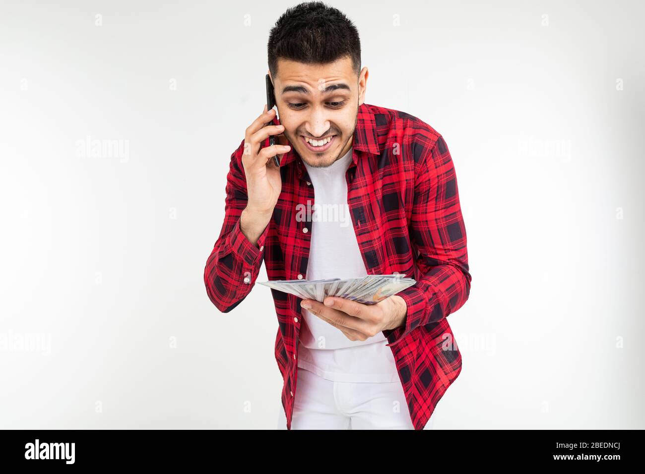 portrait of a cute guy with a bunch of money talking on the phone on a ...