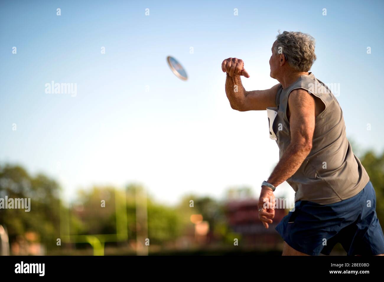 Mature man throwing a discus during an athletics event Stock Photo - Alamy