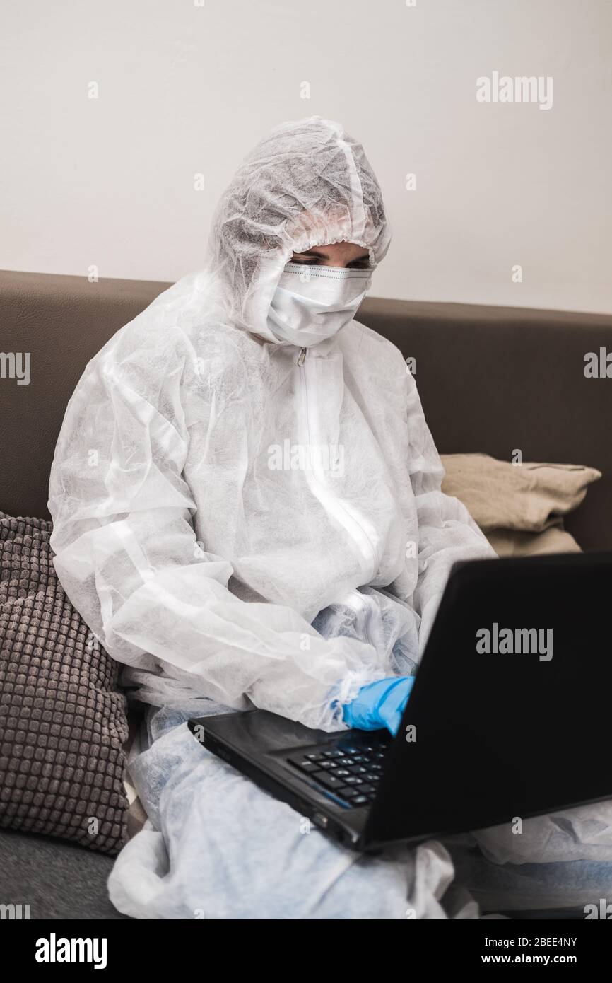 Person in protective white translucent suit, blue rubber gloves ...