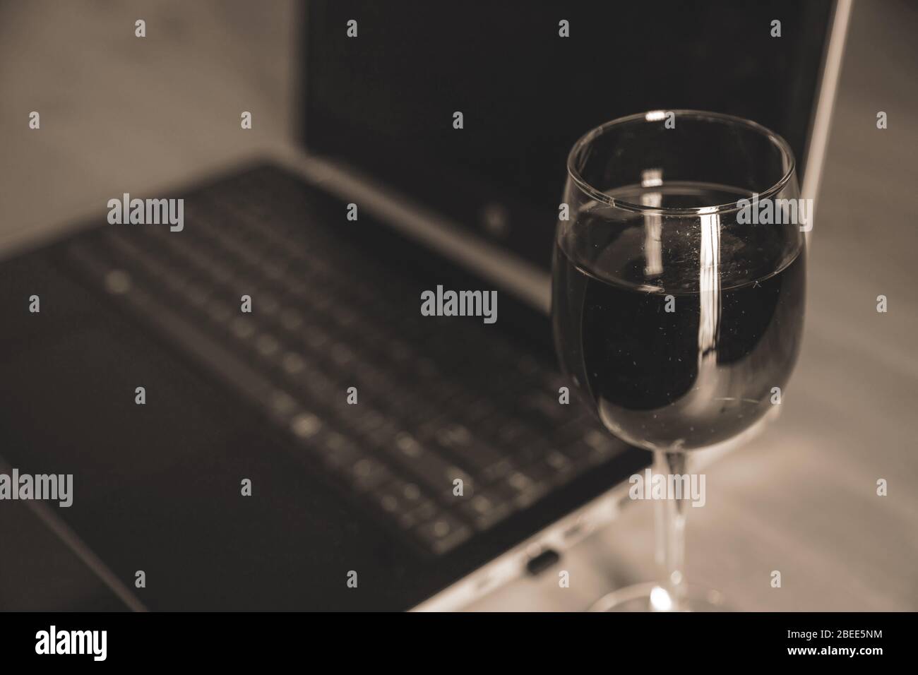 Glass of red wine and laptop on the table - working in home office and ...