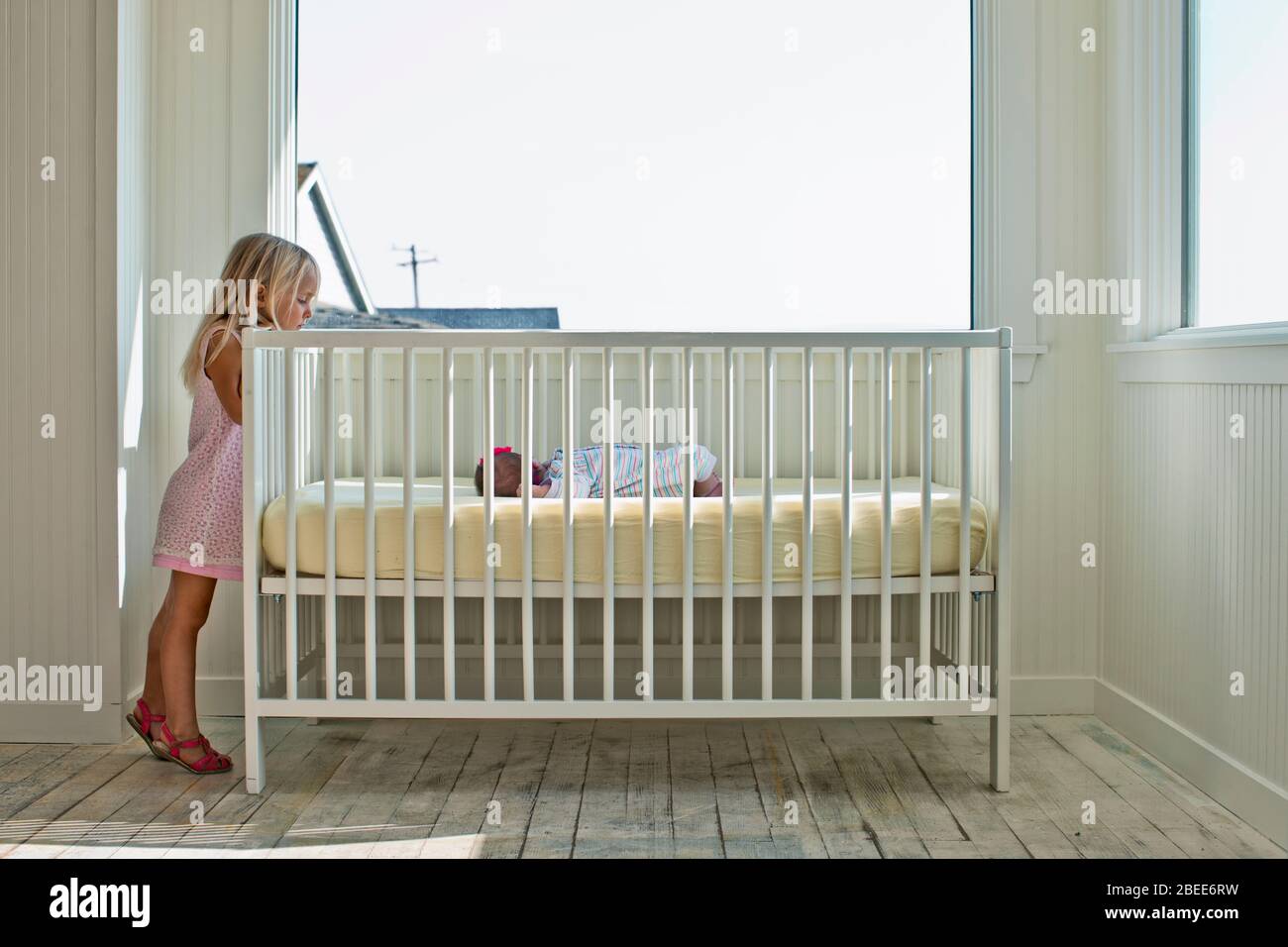 Girl peering crib hi-res stock photography and images - Alamy