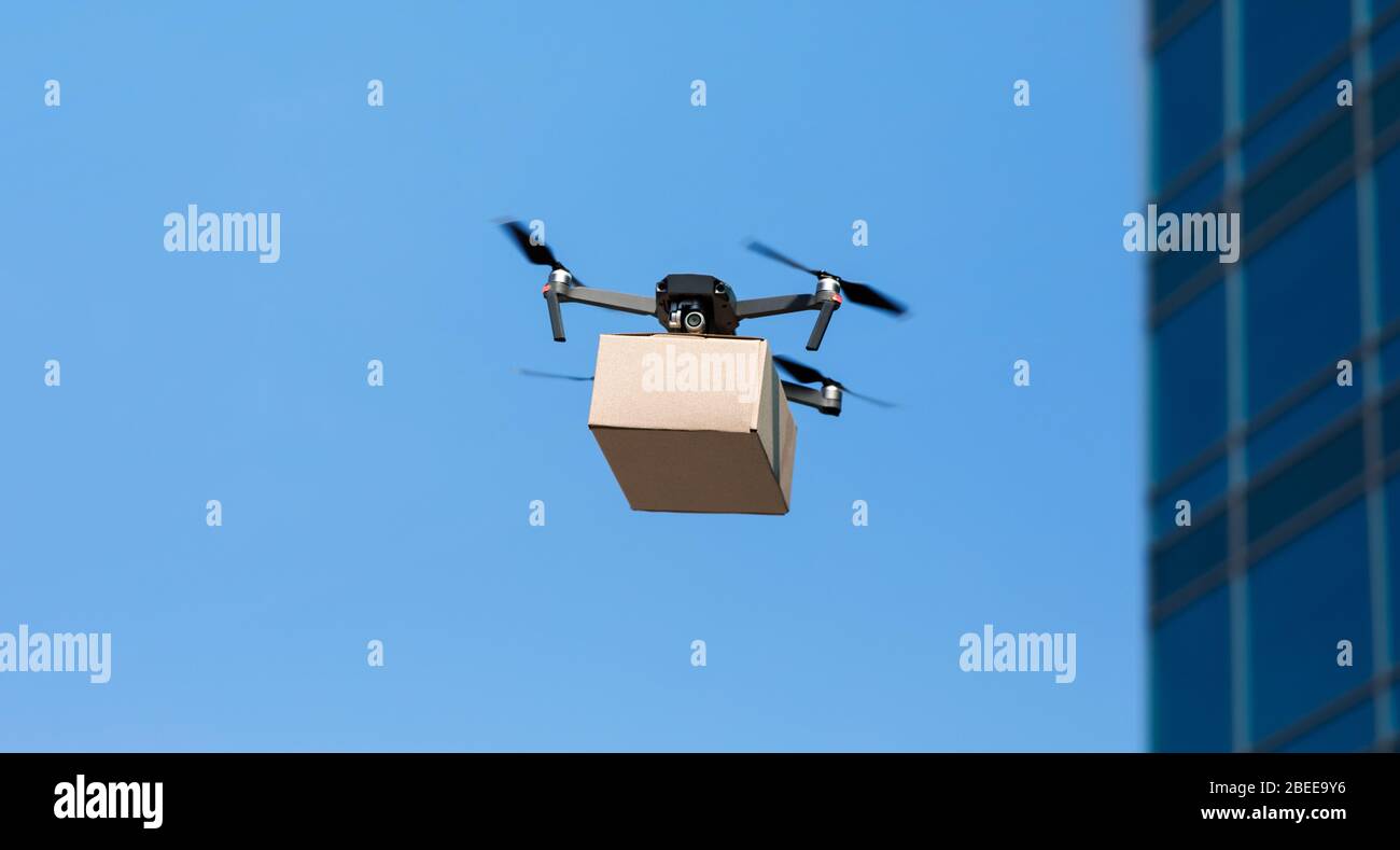 Modern drone delivering cardboard box, panorama, copy space Stock Photo ...
