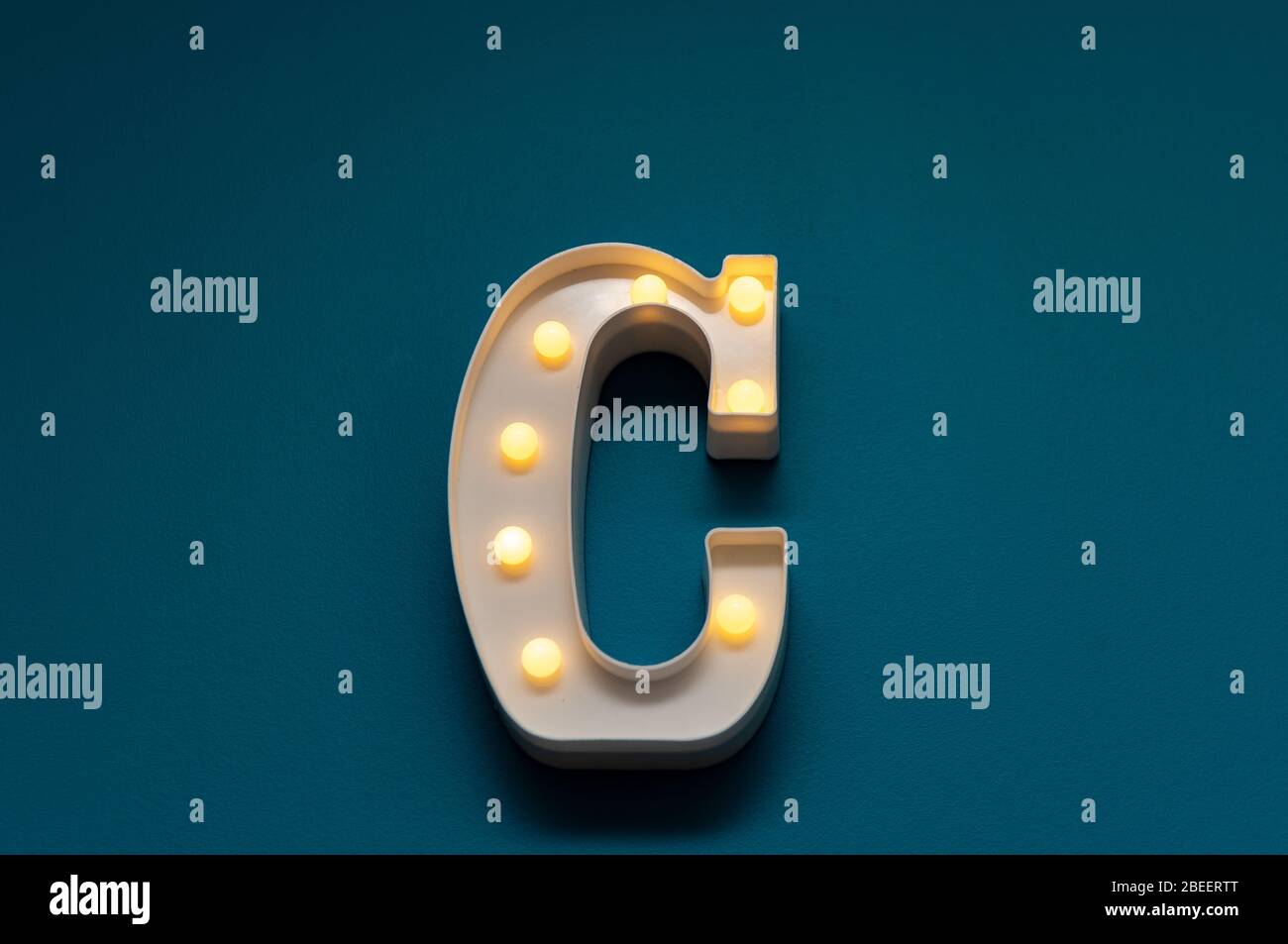 Single Light up Letter "C" on Teal wall, conceptual Stock Photo - Alamy