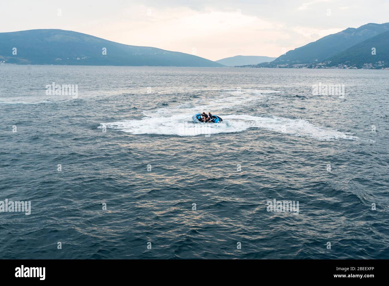 a guy and a girl riding a hydrocycle in the sea near the shore ...