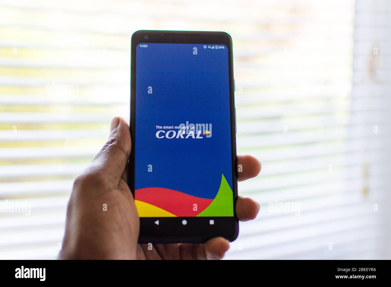 Coral app on a phone held by a man Stock Photo - Alamy