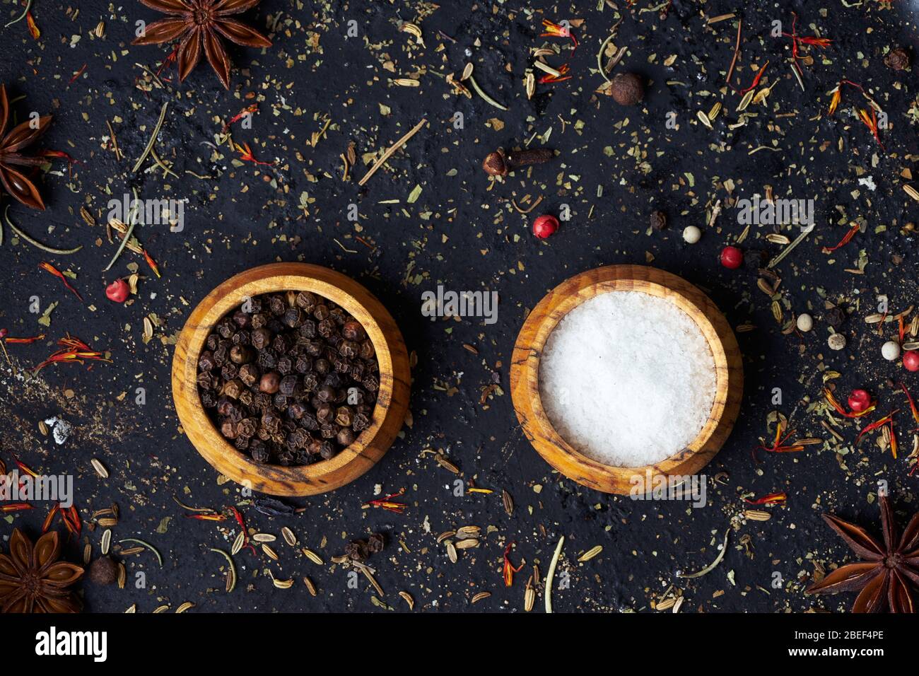 Closeup a salt and pepper shaker with spices on an old dark background ...