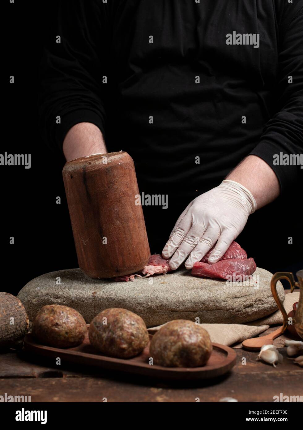 Cook makes meal meat with dark background Stock Photo - Alamy