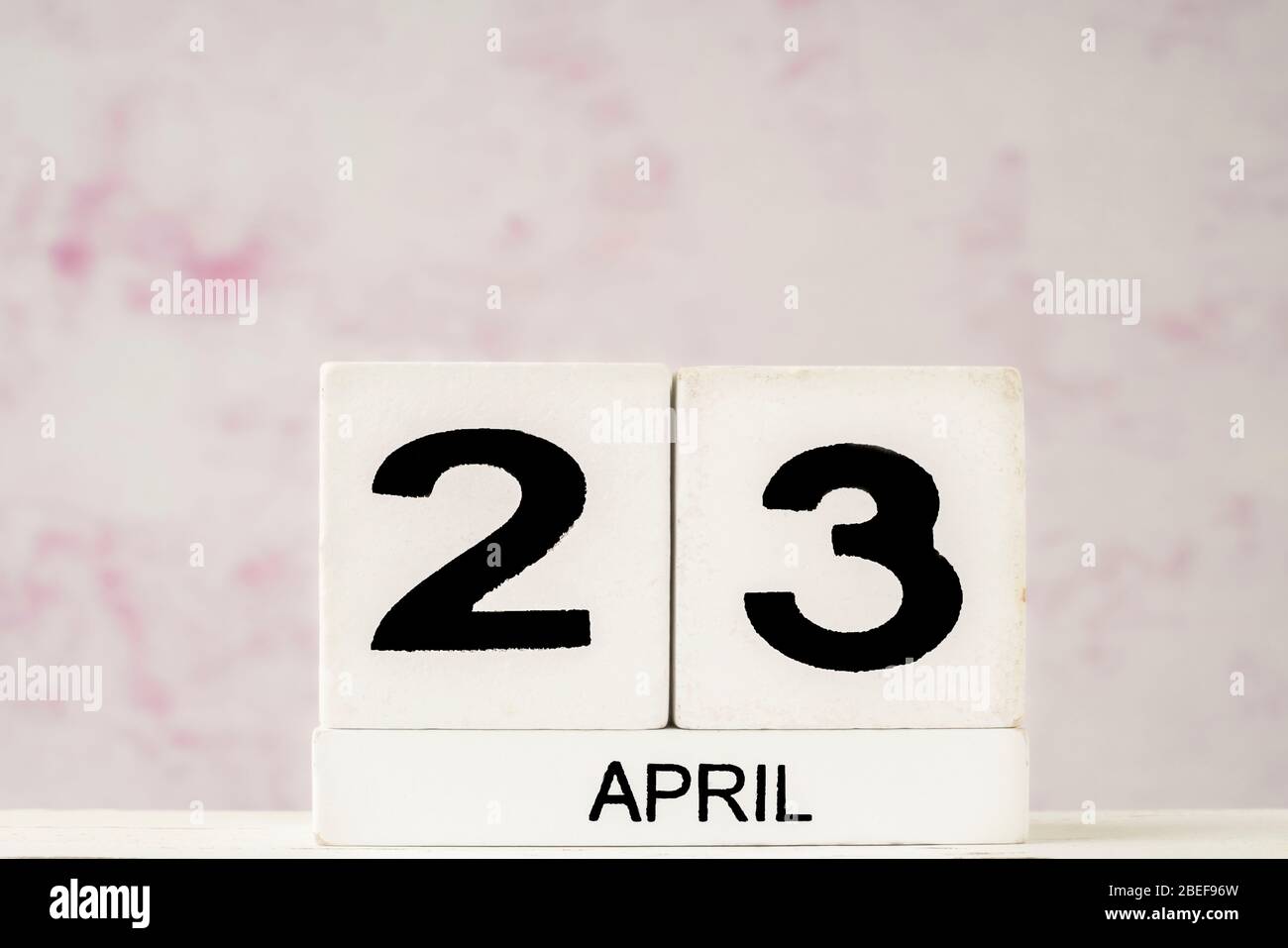 White cube calendar for April against soft pink background with copy ...