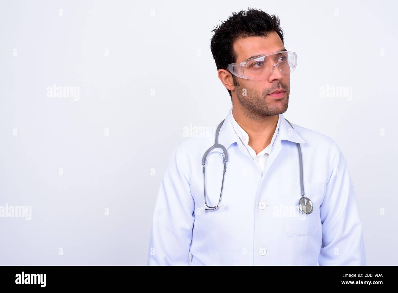 Handsome Turkish man doctor wearing protective glasses against white ...