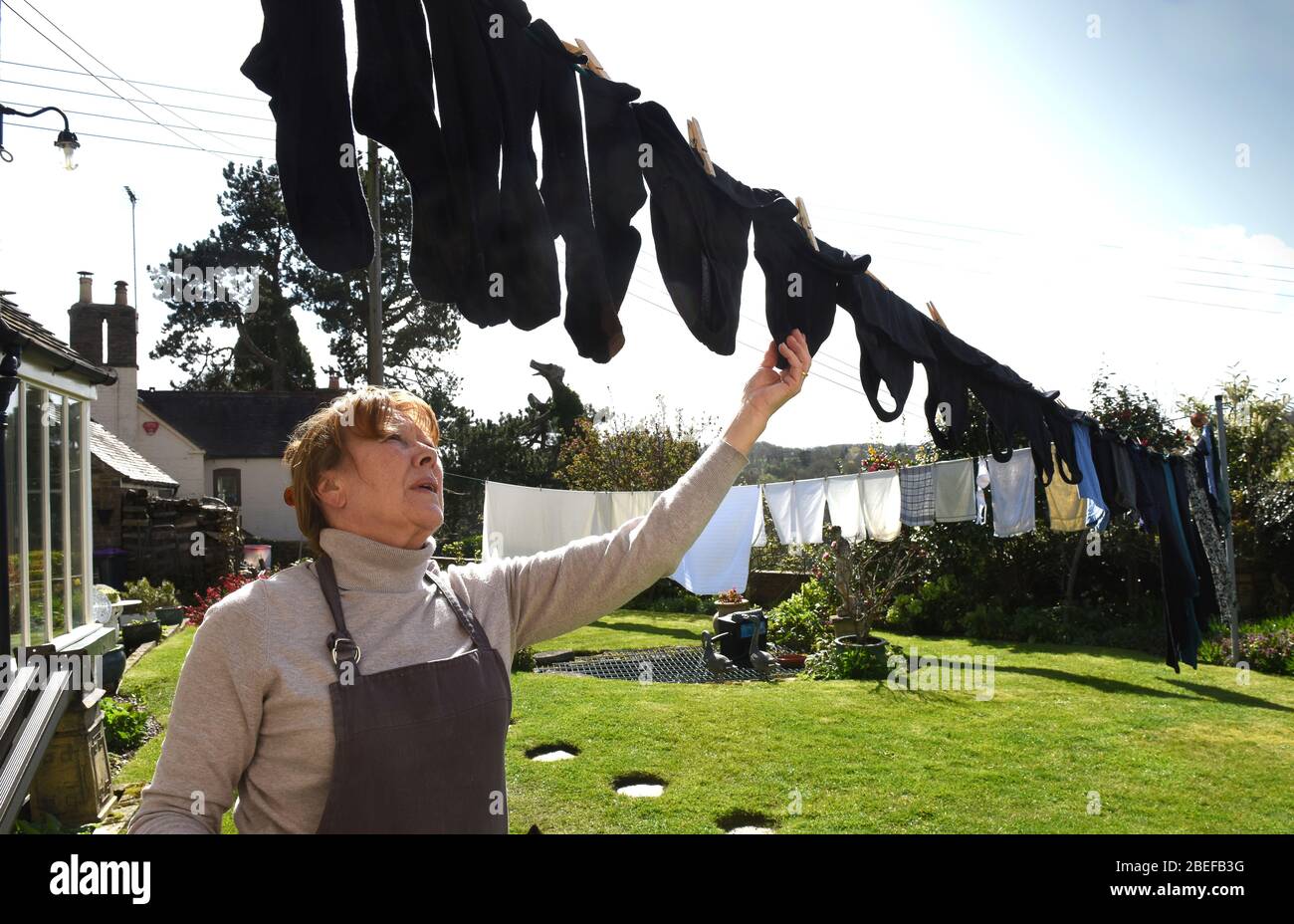 Woman hanging washing on clothes line Stock Photo - Alamy