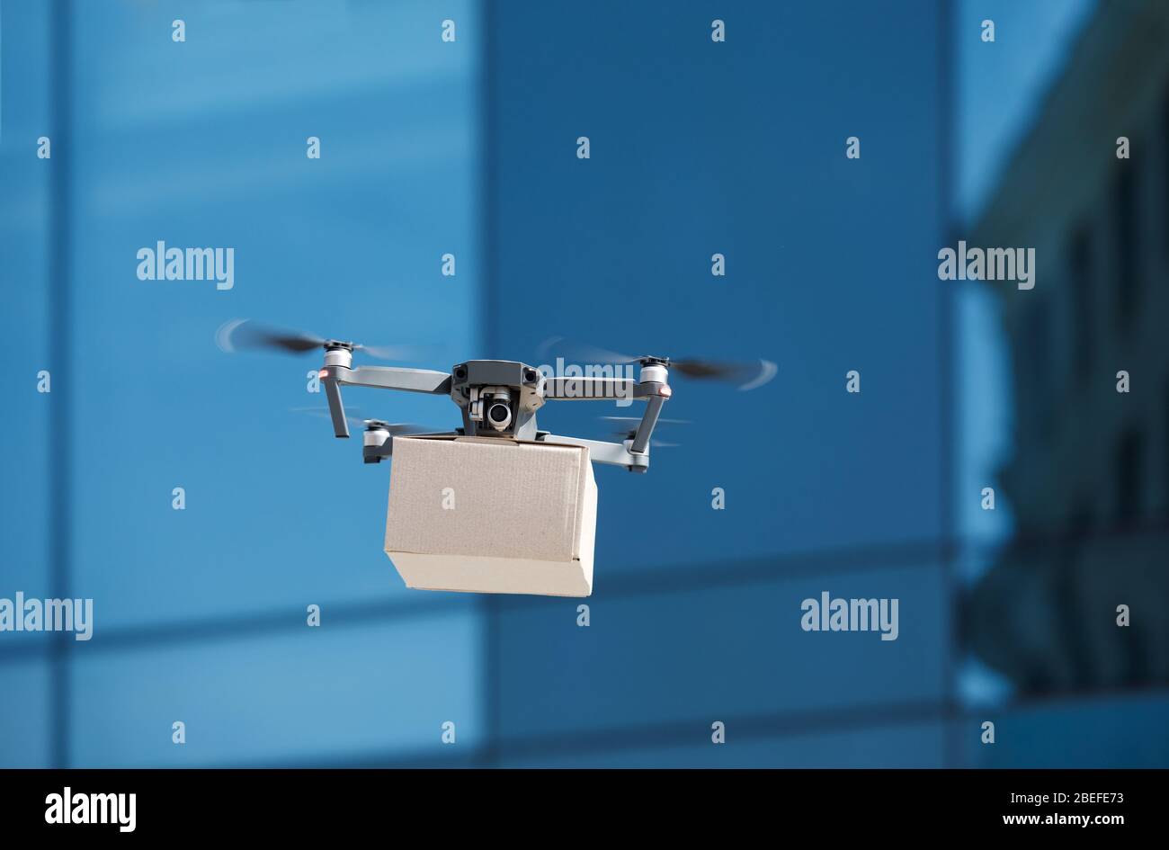 Modern drone delivering packages against city background Stock Photo ...