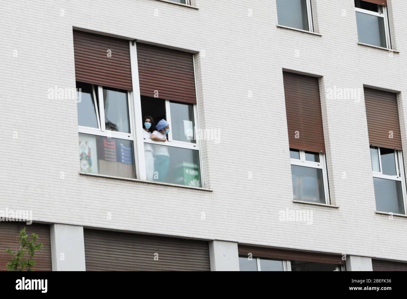 Two nurses look out the window of the Buzzi hospital during a moment of ...