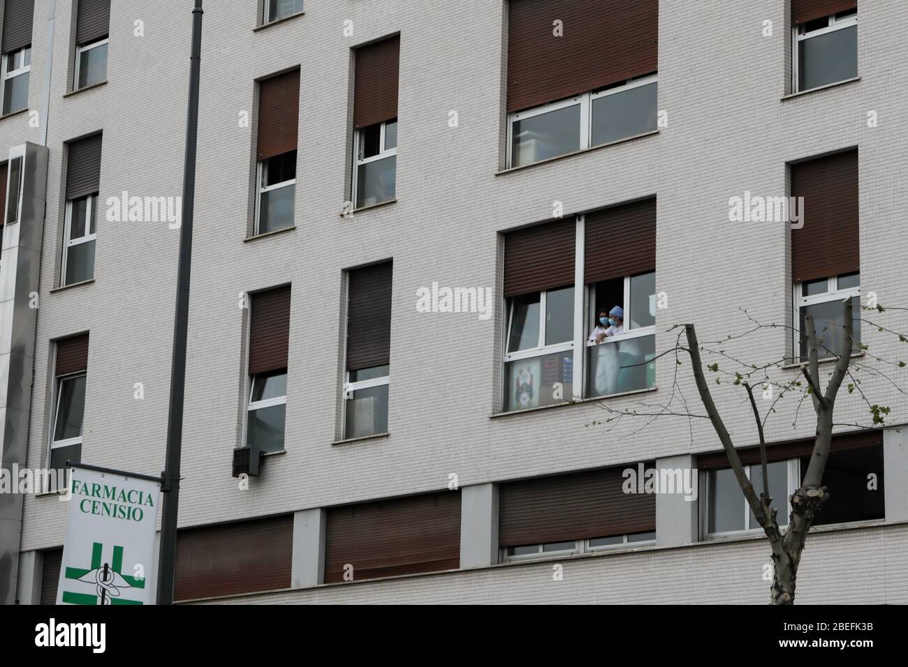 Two nurses look out the window of the Buzzi hospital during a moment of ...