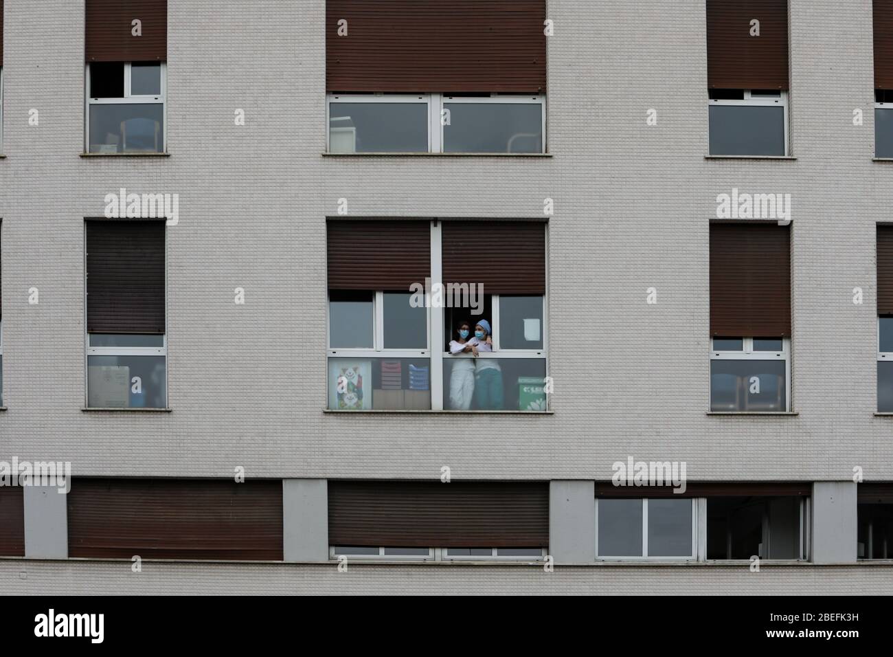 Two nurses look out the window of the Buzzi hospital during a moment of ...