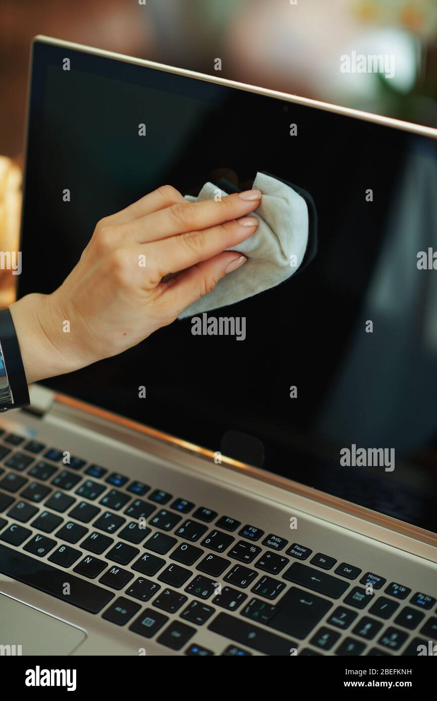 Closeup on woman cleaning laptop display with cleaning cloth at home in ...