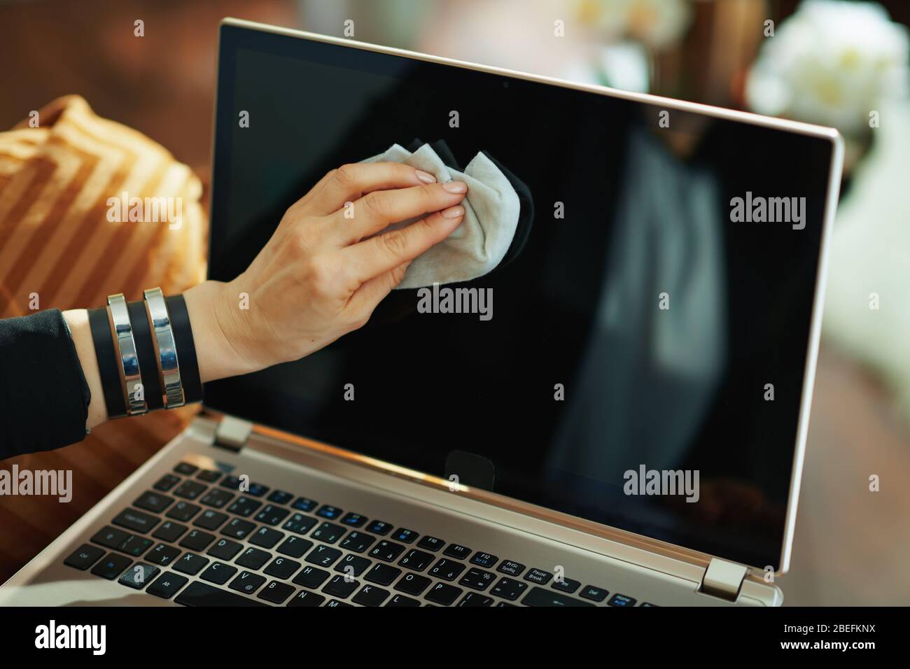 Closeup on woman wiping laptop display with cleaning cloth in the ...