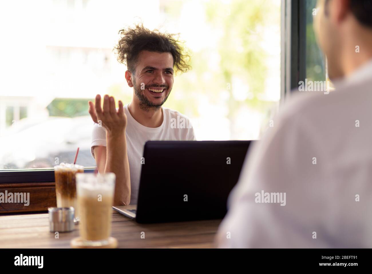 Two happy men as friends talking together at the coffee shop Stock ...