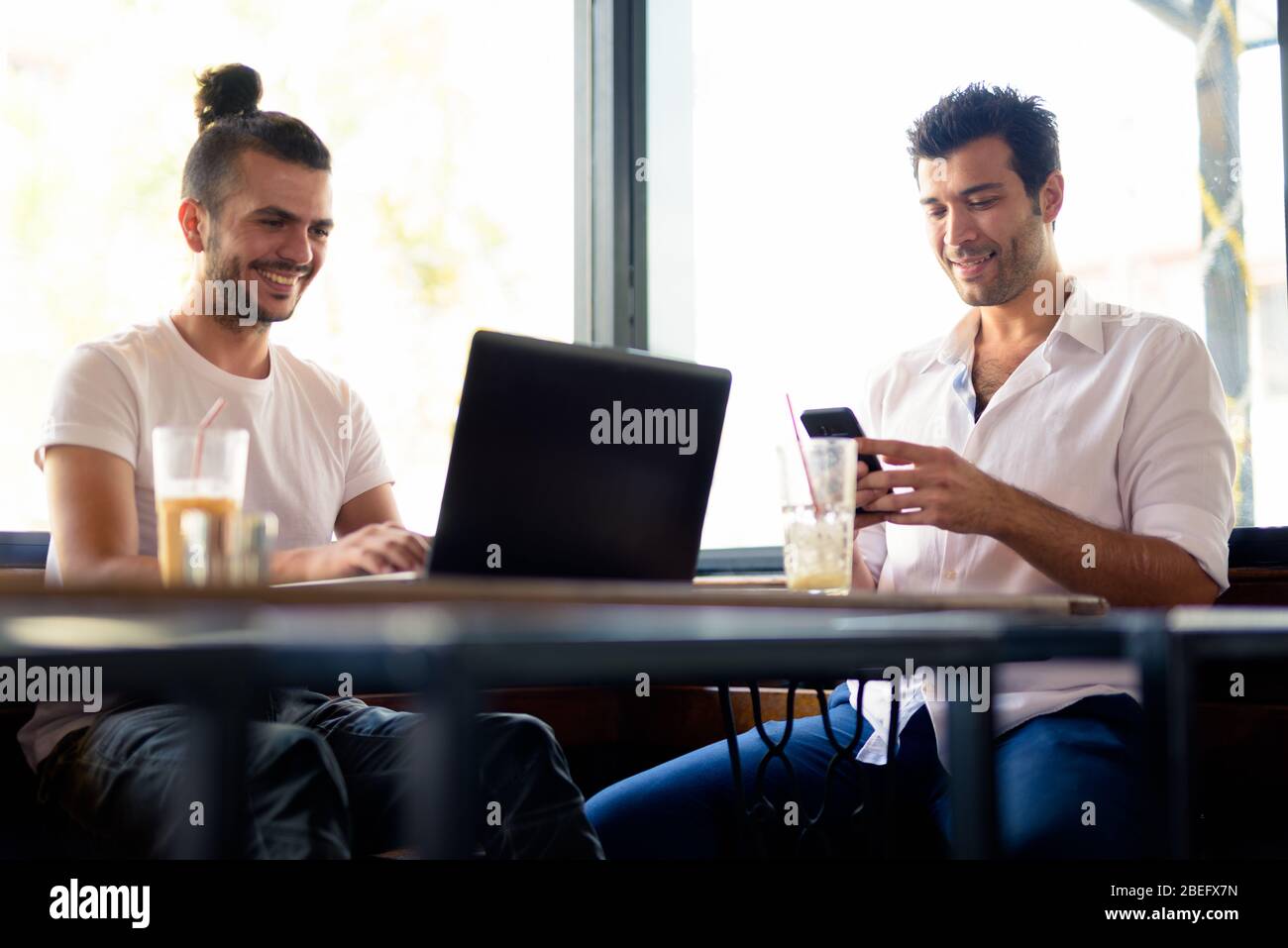 Two happy men as friends working together at the coffee shop Stock ...
