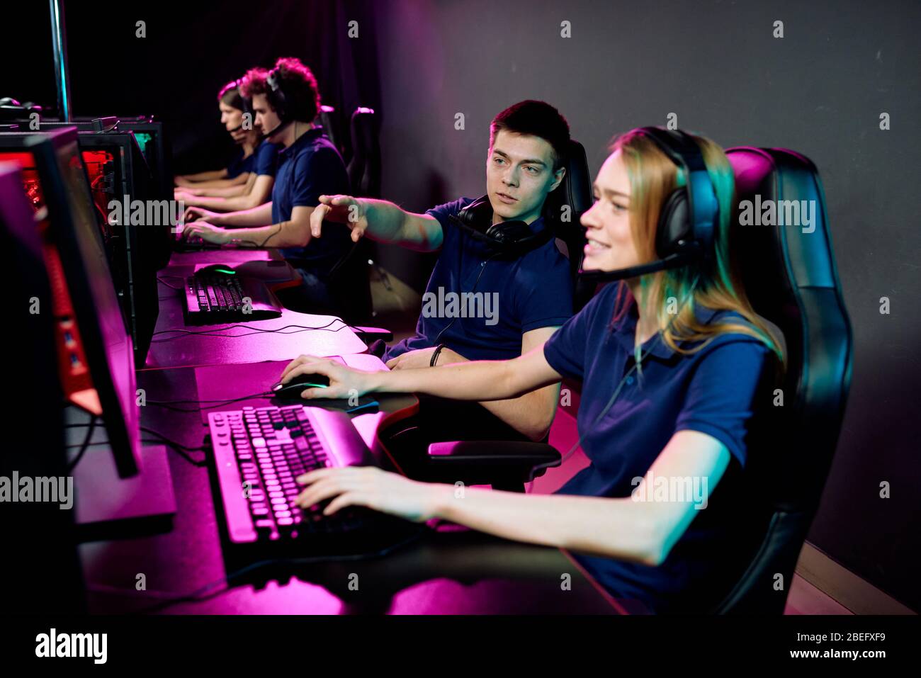 Young cyber sport gamer giving advice to girl in headphones while they ...