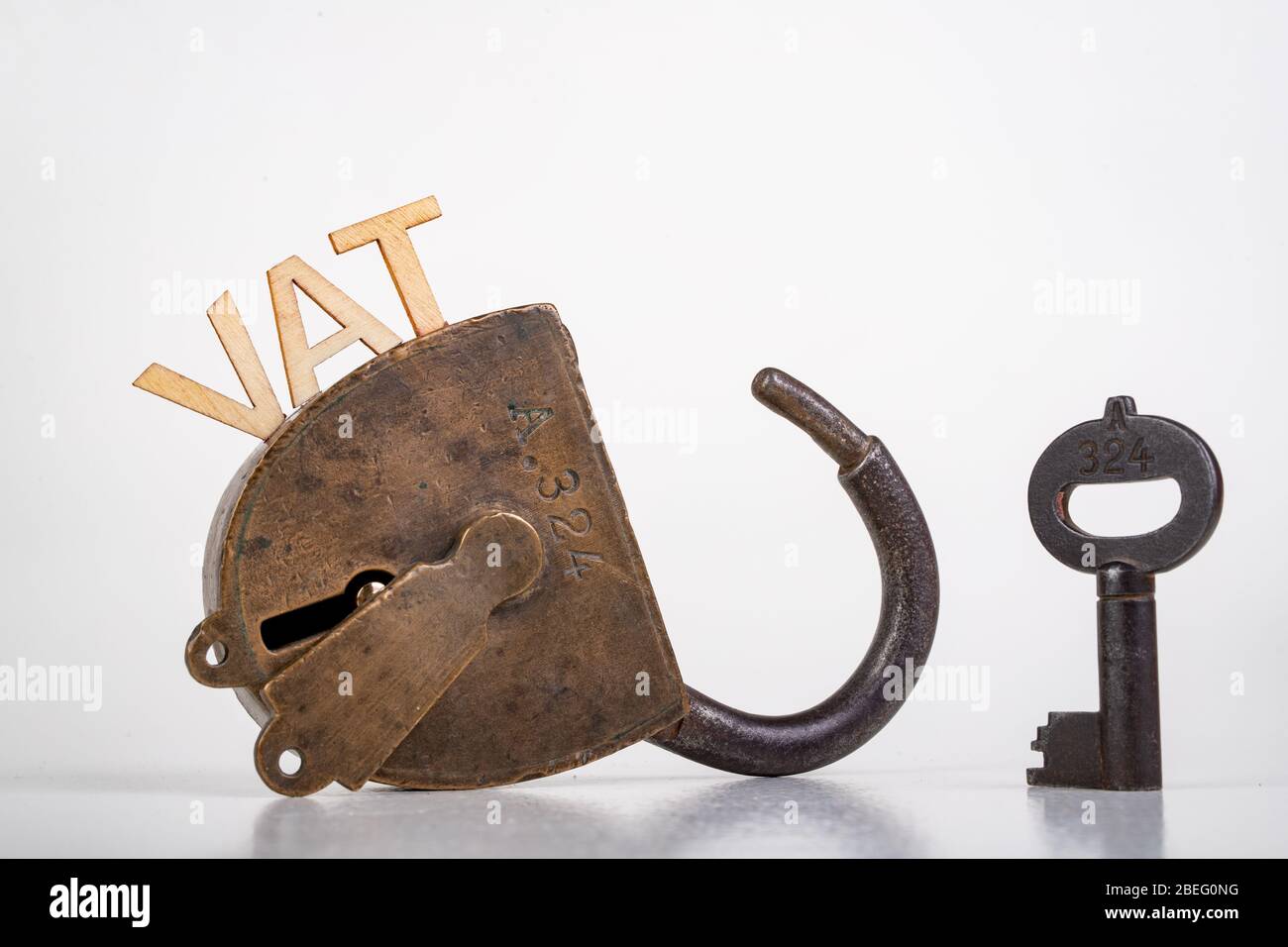 The inscription VAT made of wooden letters. Old antique padlock and key ...