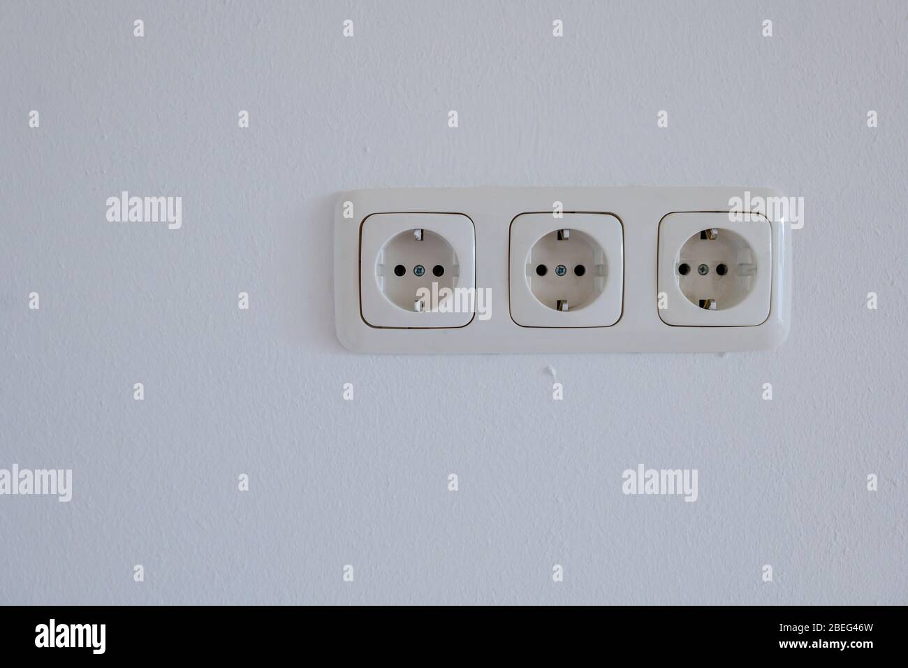 Real triple European socket or outlet Type F on white painted plaster ...
