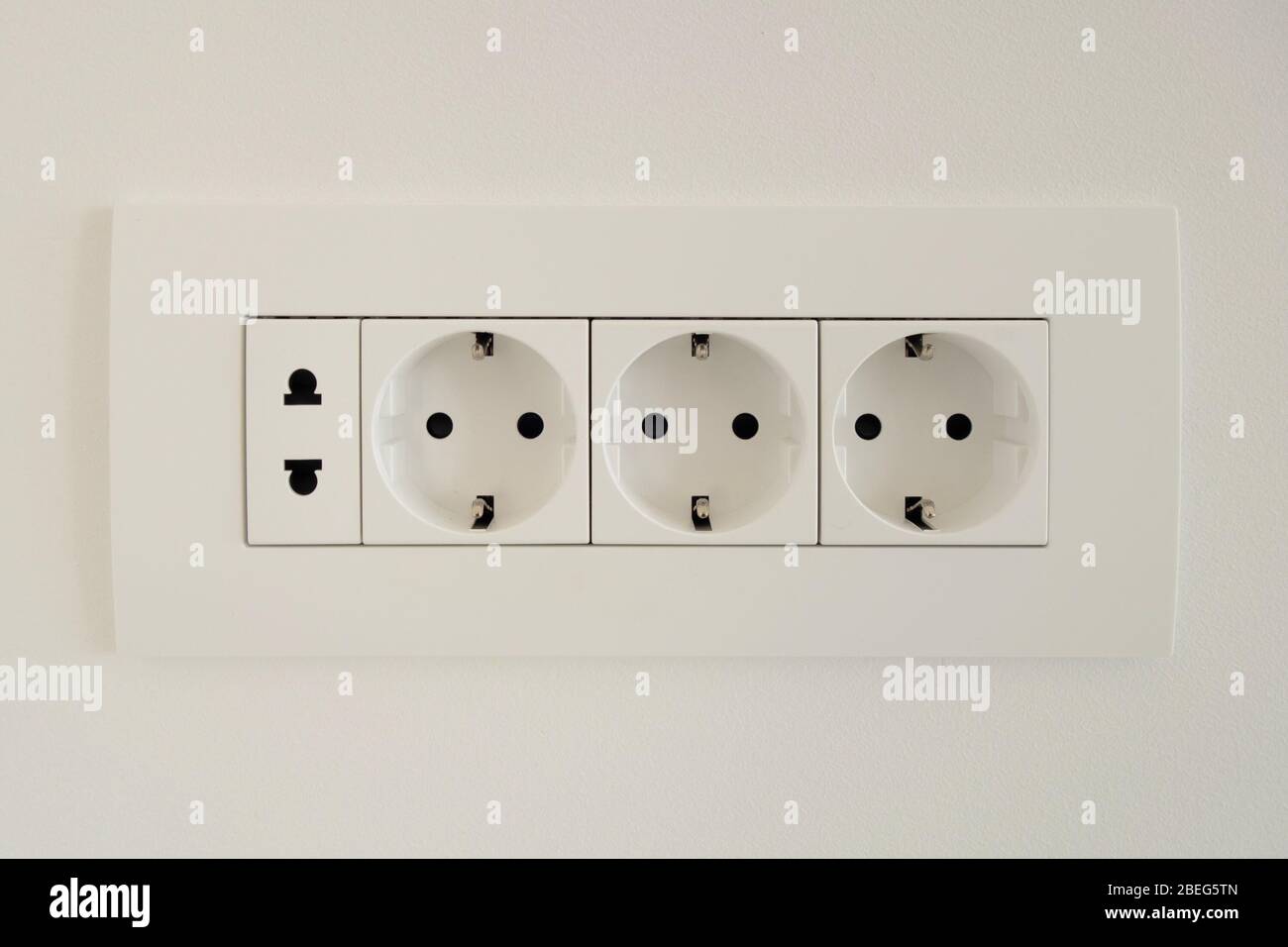 A block of white outlets consisting of three EU standard outlets with ...