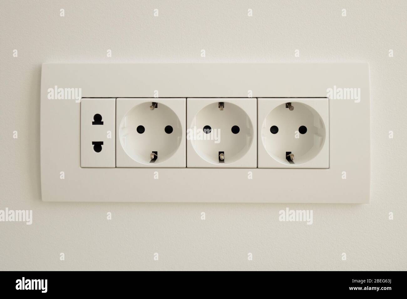 A block of white outlets consisting of three EU standard outlets with ...
