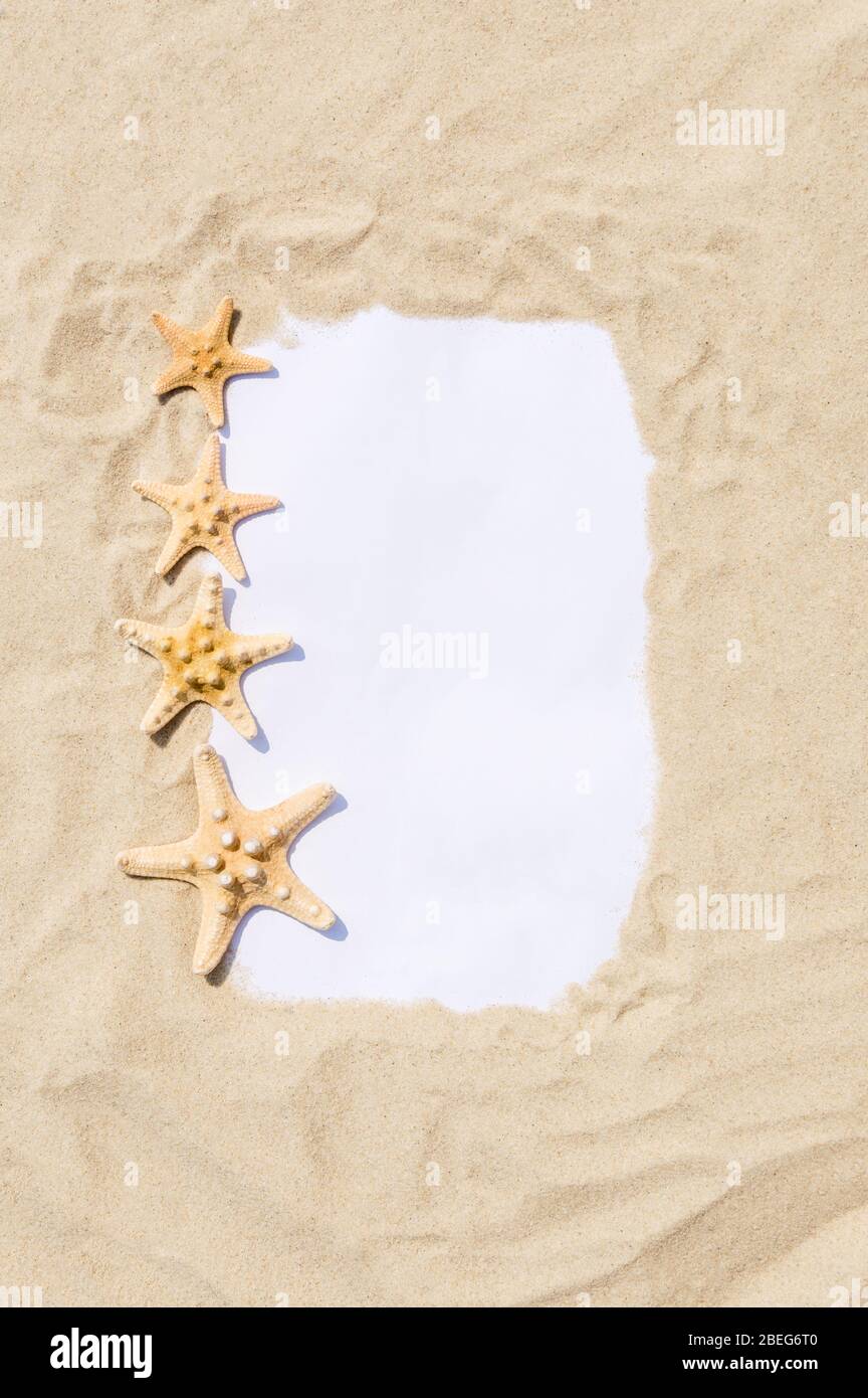 A note paper framed with sea sand and starfish on golden sandy beach on ...