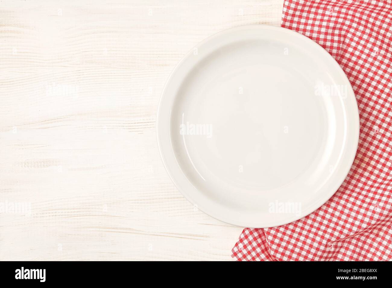 Empty plate with red napkin over white wooden table background Stock ...