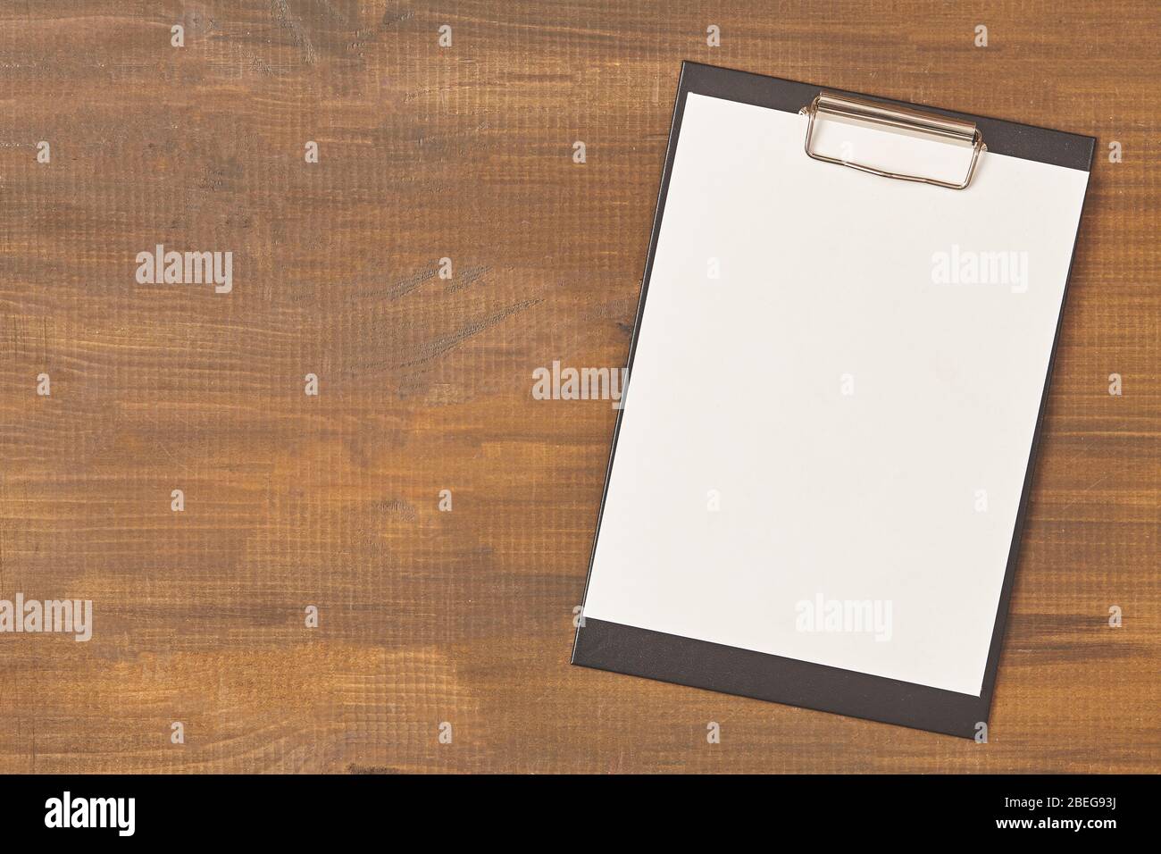 Clipboard with a blank sheet of paper on wooden table with copy space ...