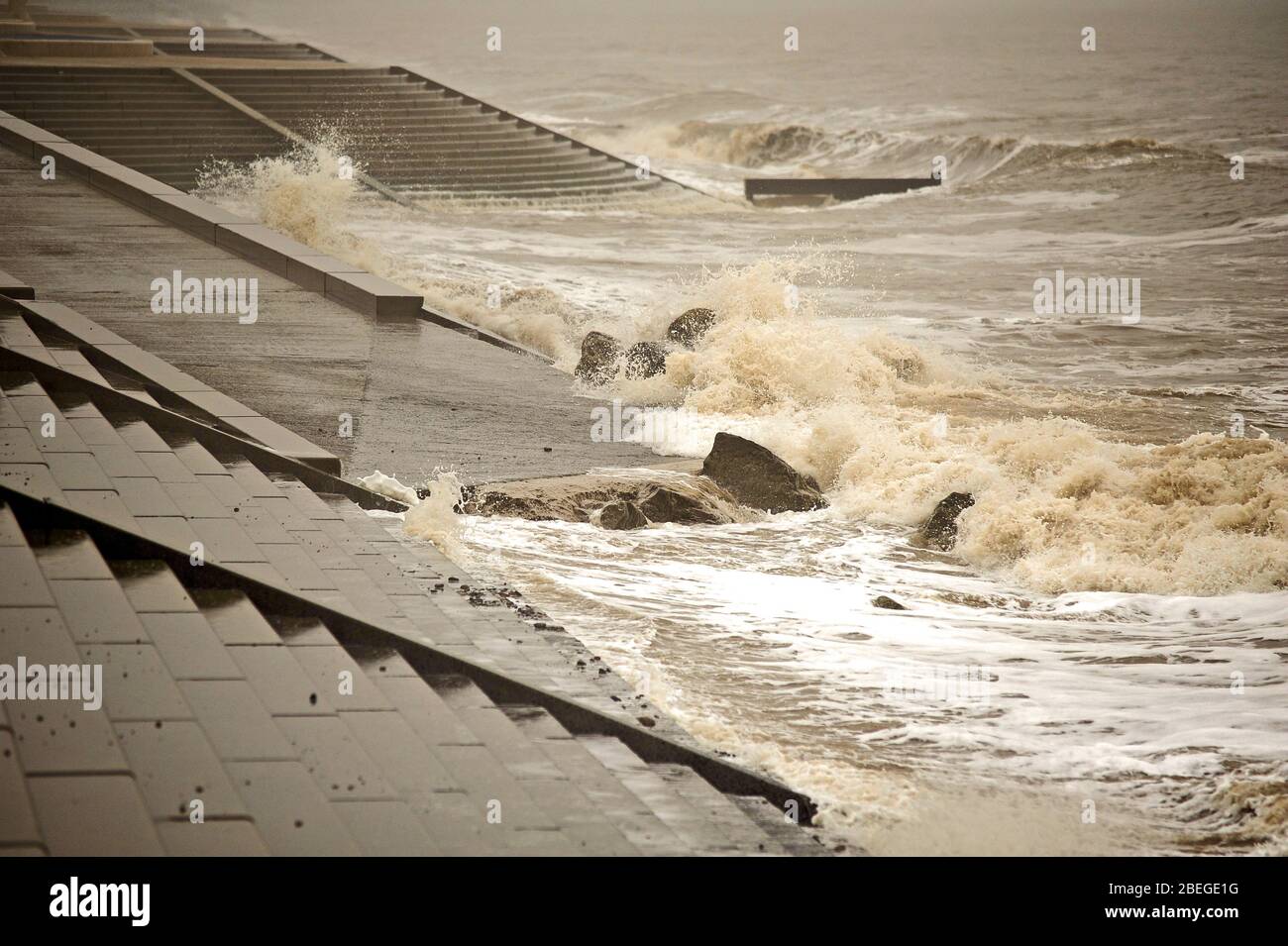 Concrete ramp and steps leading to to a rough sea at high tide at ...