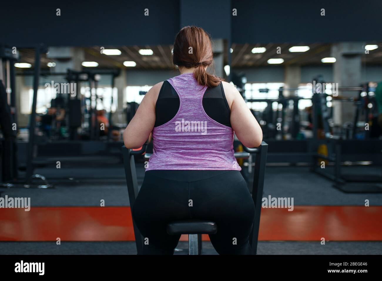 Overweight woman doing exercise in gym, back view Stock Photo - Alamy