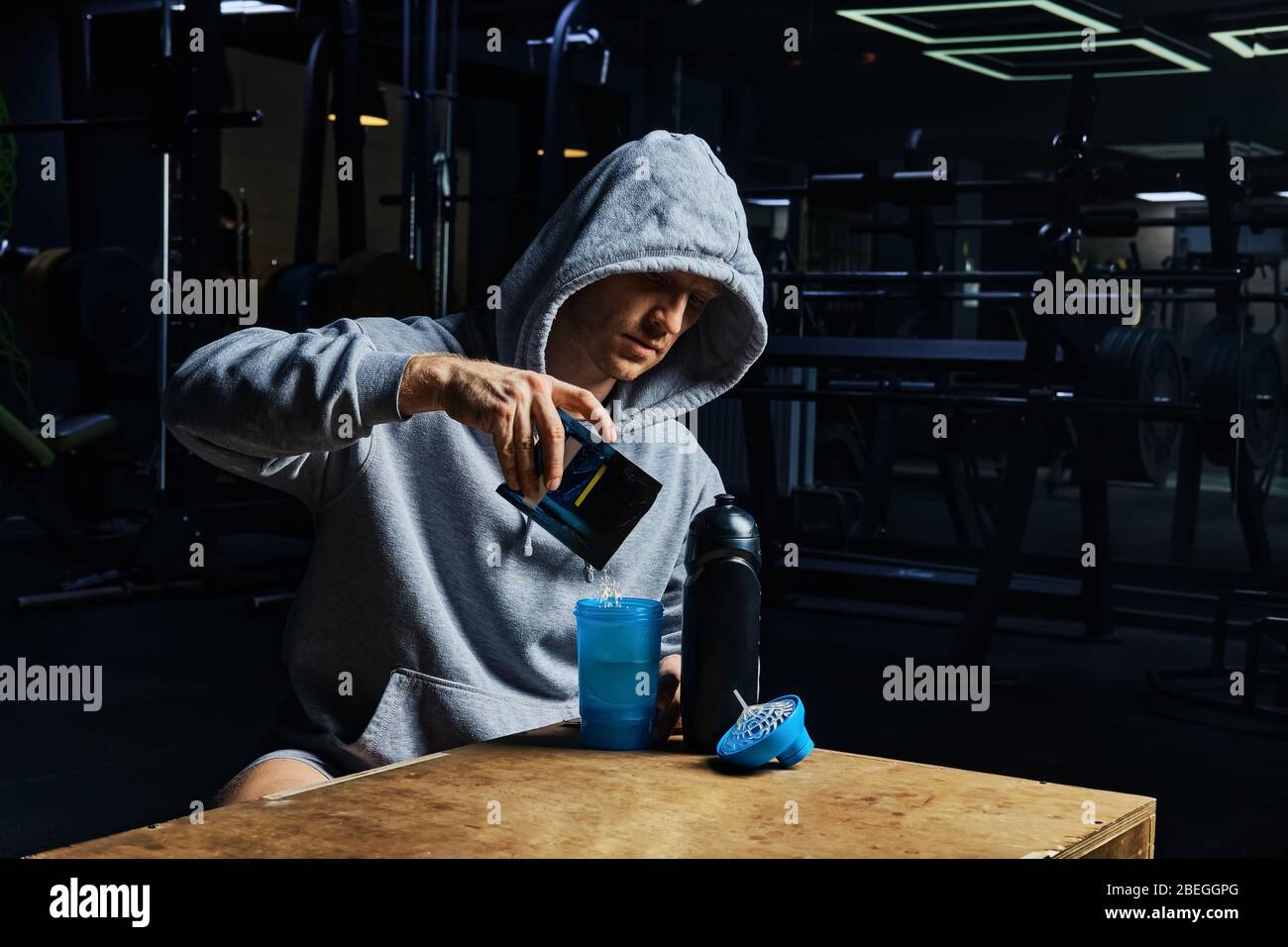 Man pouring energy sports supplement in bottle Stock Photo - Alamy