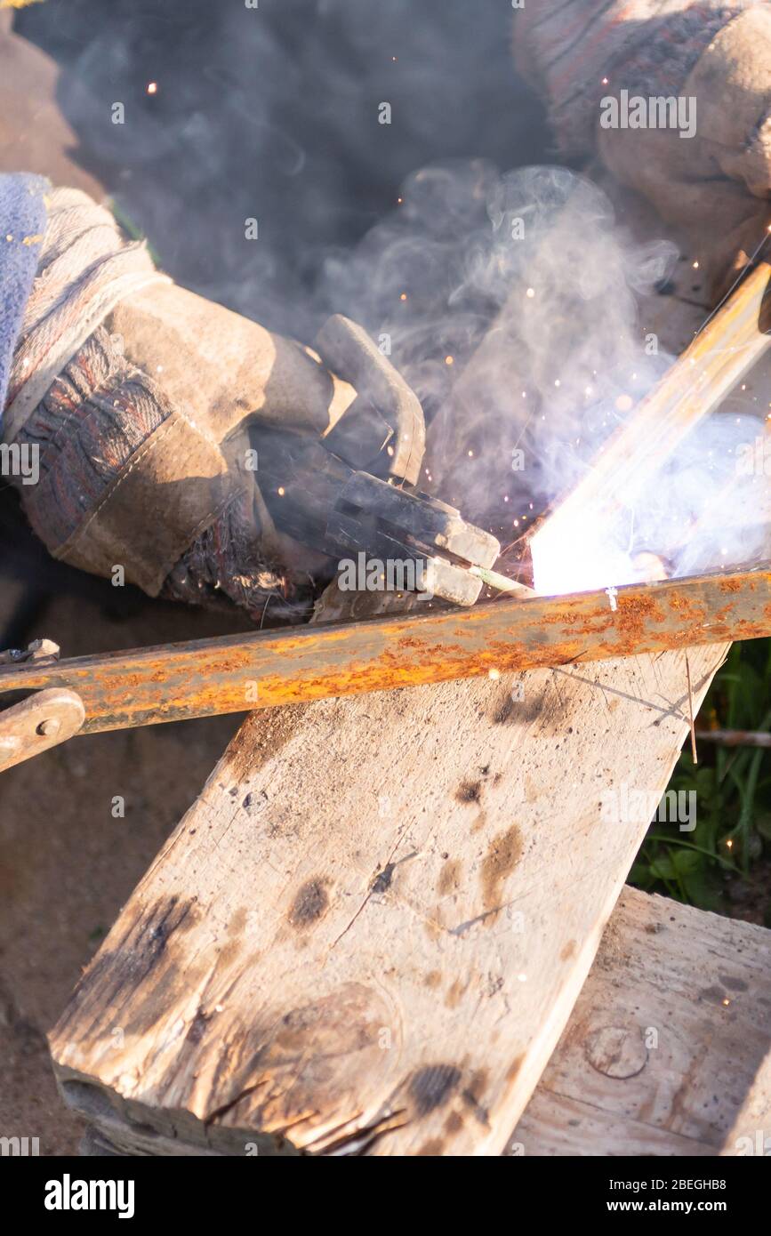 Welding iron. The worker welds the iron parts. Workplace on a pallet ...
