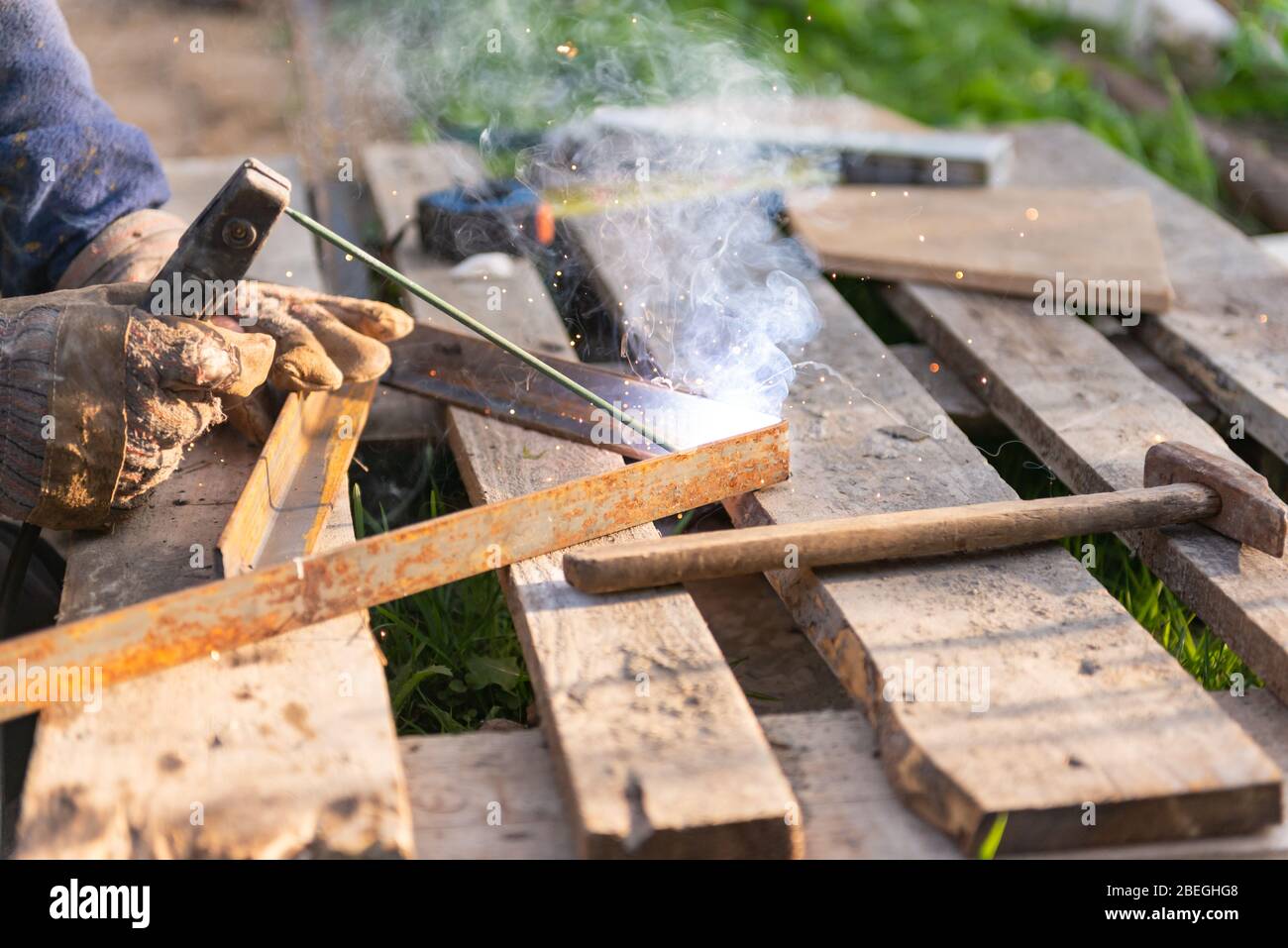 Welding iron. The worker welds the iron parts. Workplace on a pallet ...