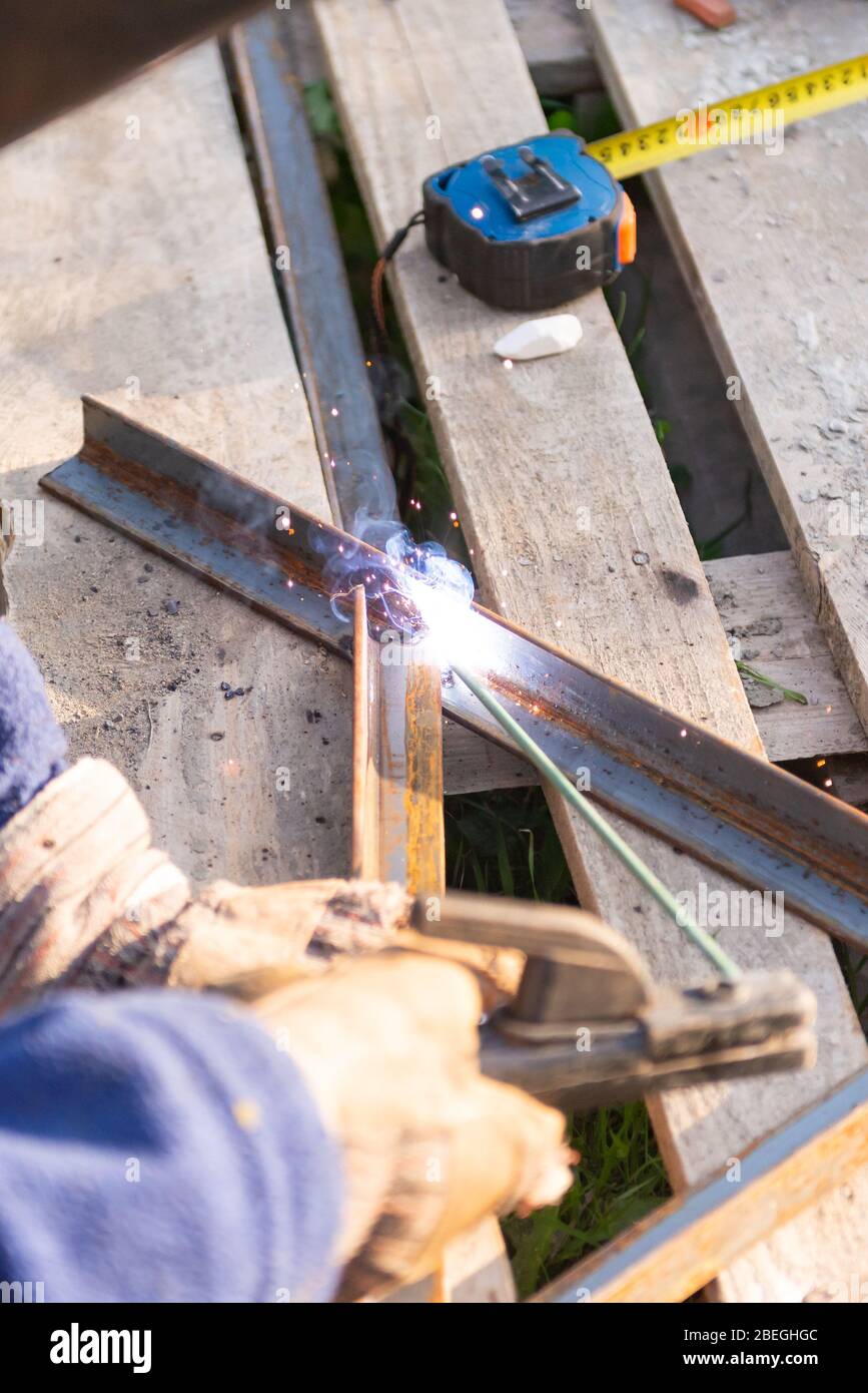 Welding iron. The worker welds the iron parts. Workplace on a pallet ...