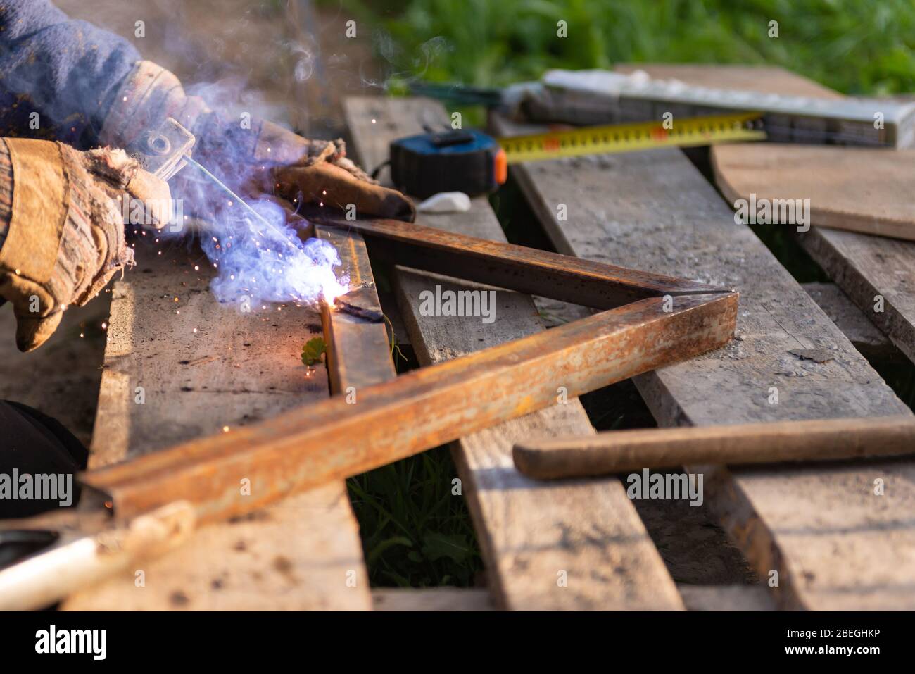 Welding iron. The worker welds the iron parts. Workplace on a pallet ...
