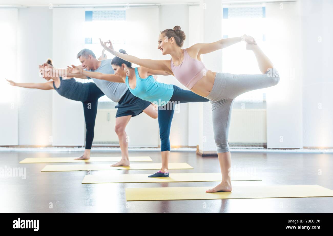 Four young and fit yoga students in dancer pose Stock Photo - Alamy