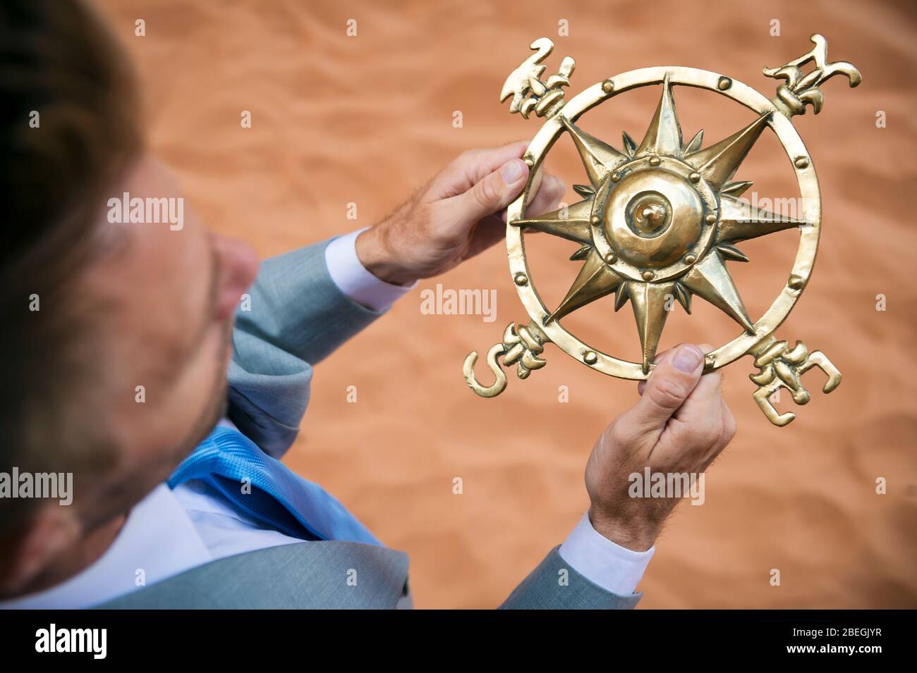 Lost man holding a traditional old-fashioned compass rose outdoors in ...