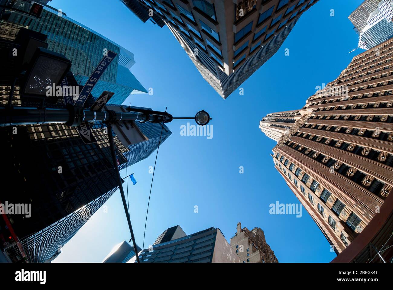 Abstract view from below of skyscraper canyon with blue sky at the ...