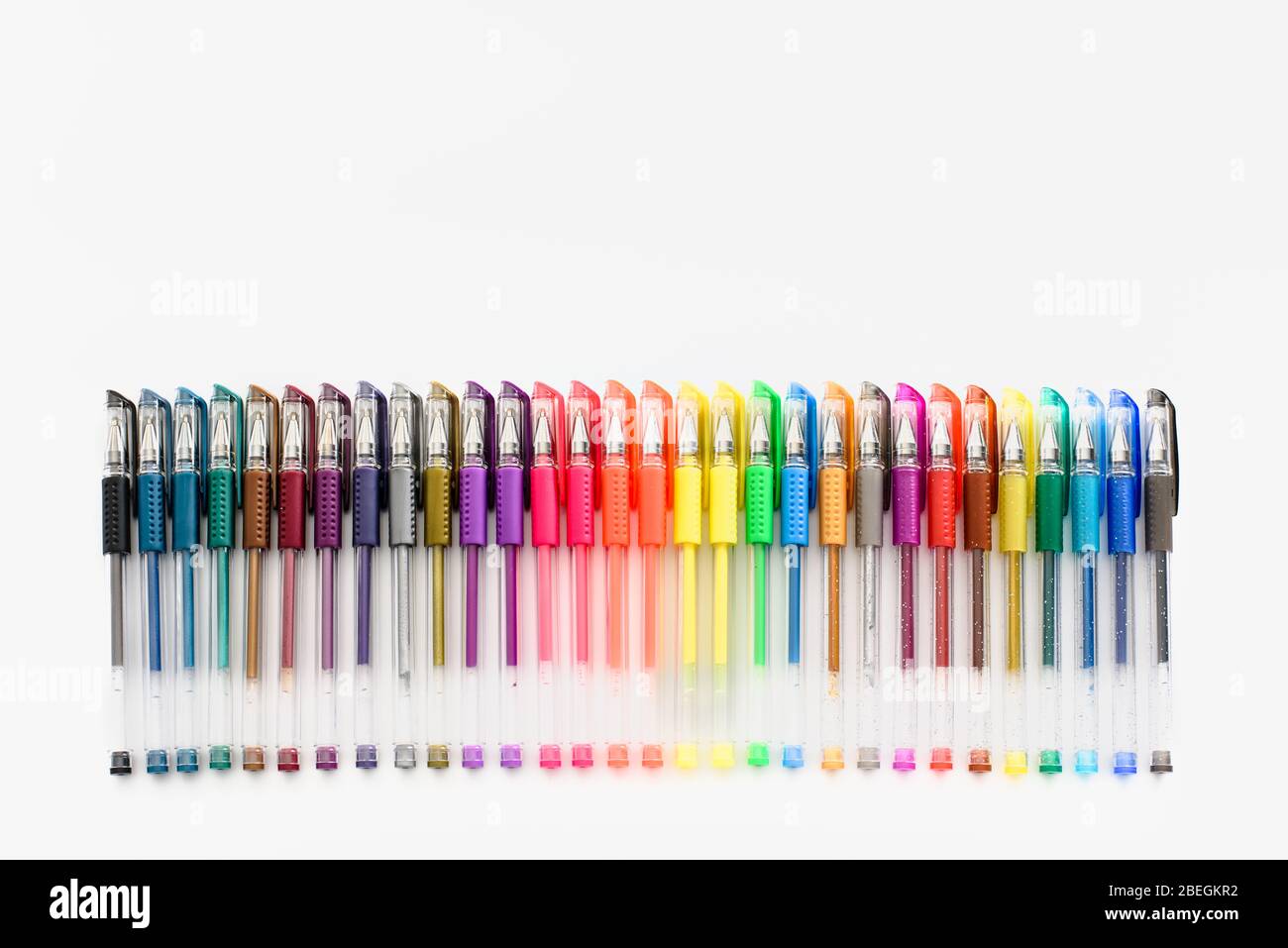 Set of colored pens arranged on a white studio table with isolated copy ...