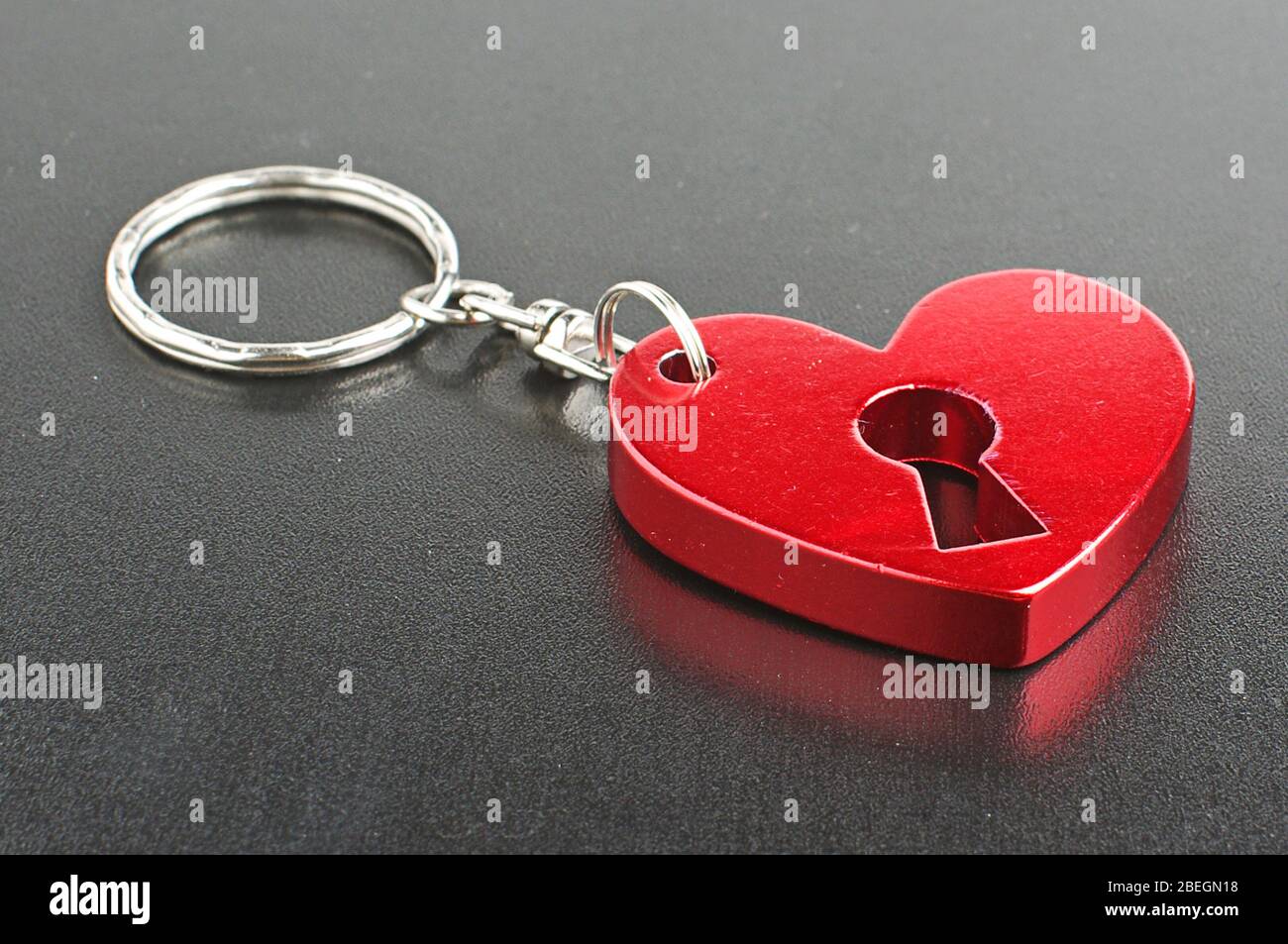 Red heart shape key chain with key hole isolated on the black ...