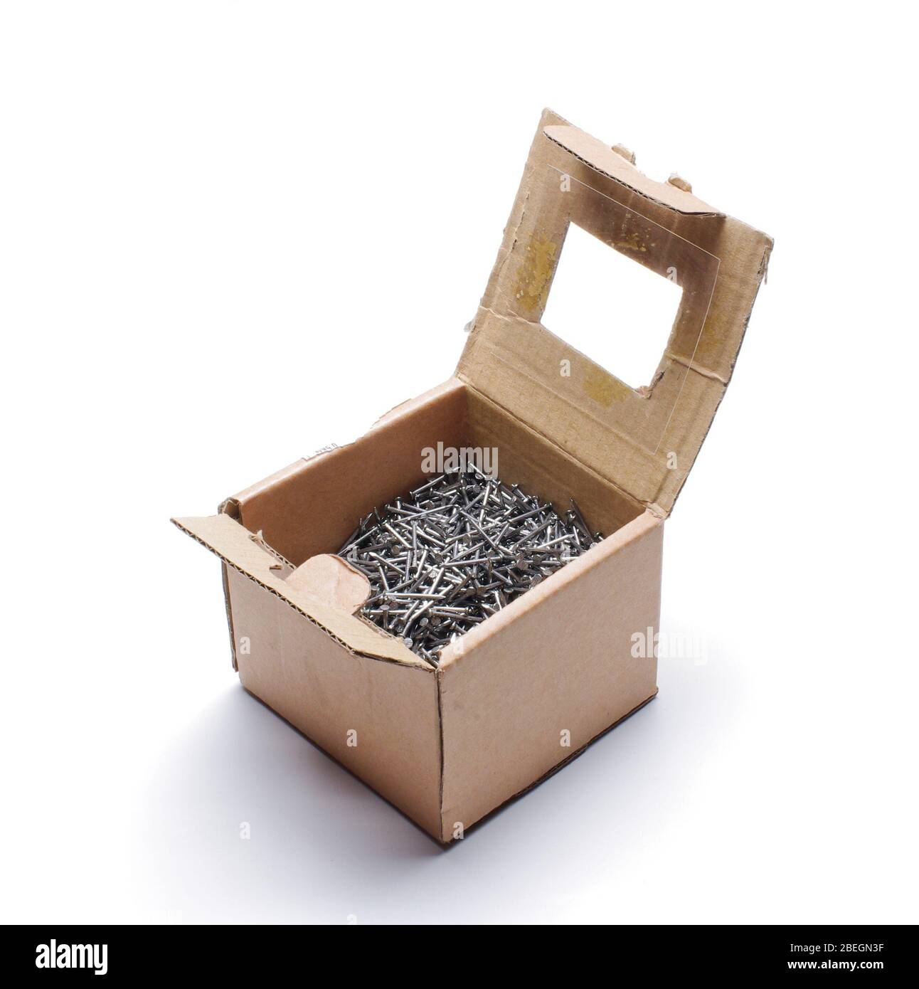 Many nails packed in the cardboard box isolated on the white background ...