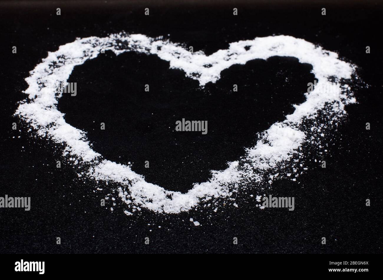 Heart shape made from salt isolated on the black background Stock Photo ...