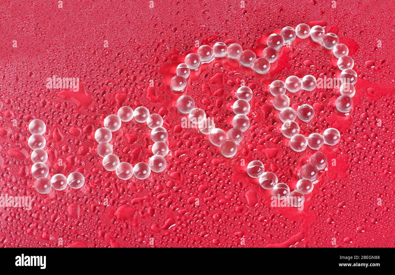 Crystal glass balls assembled in text LOVE on the red background Stock ...