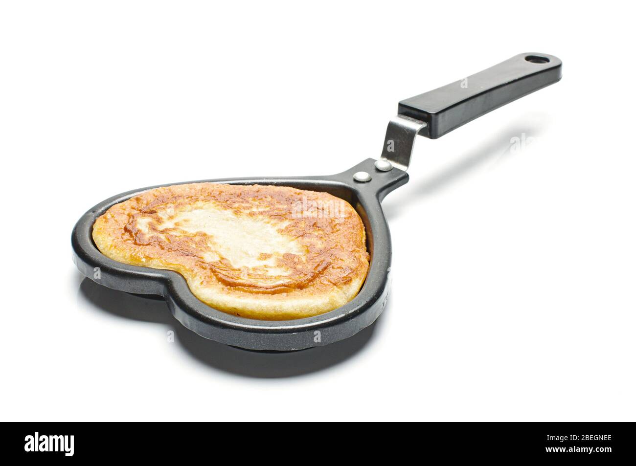 Heart shape flapjack in the pan isolated on the white background Stock ...