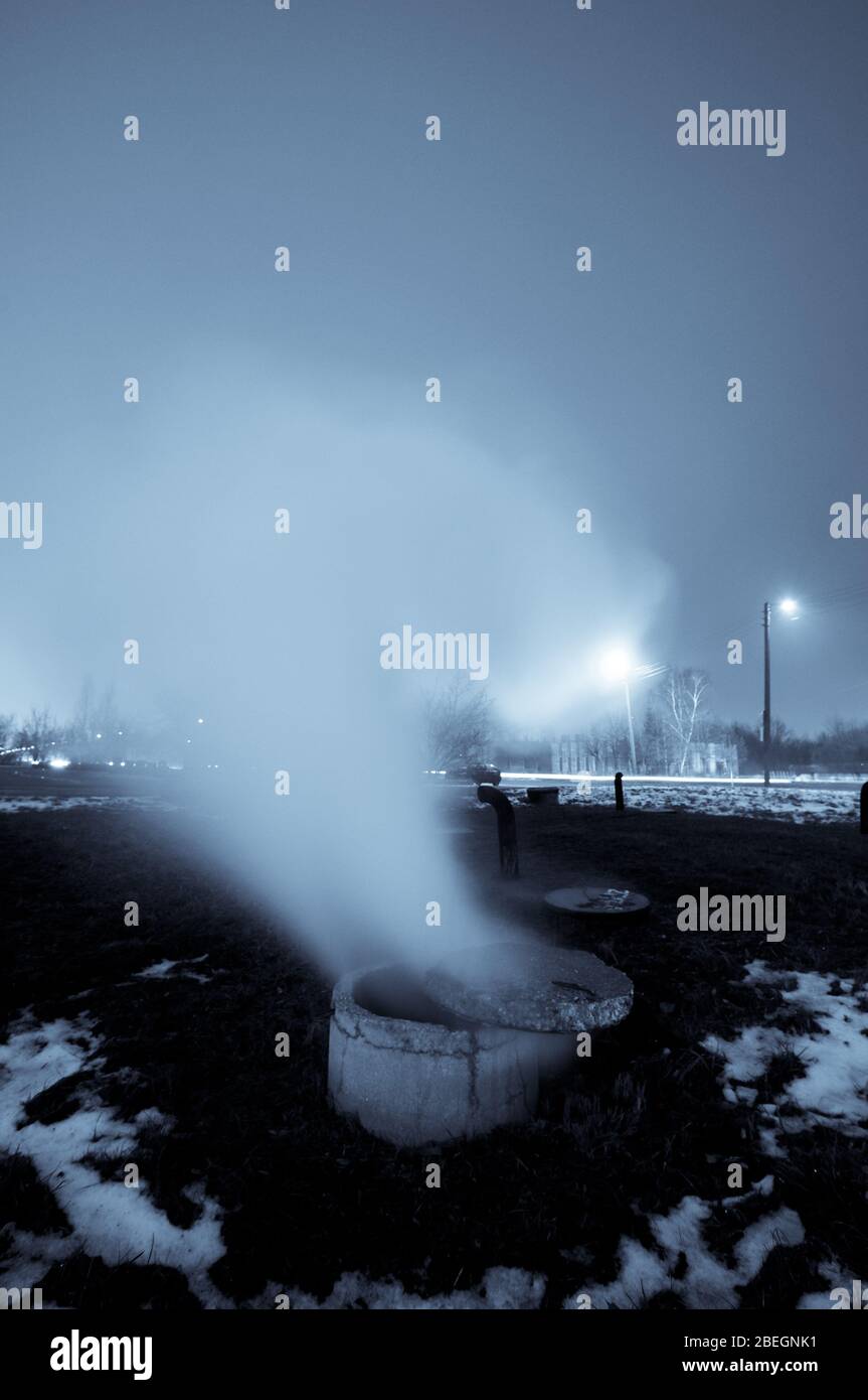 Toxic steam from well on the street. Pollution concept Stock Photo - Alamy