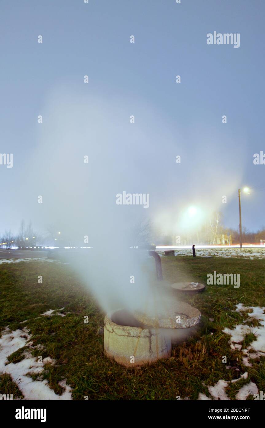 Toxic steam from well on the street. Pollution concept Stock Photo - Alamy