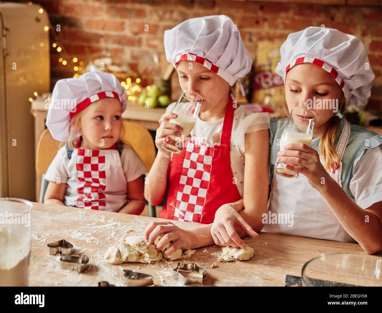 children drinking milk in kitchen. Cooking girls Stock Photo - Alamy